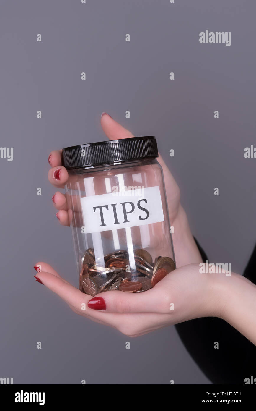 Woman's hands holding a screw cap jar for tips Stock Photo - Alamy