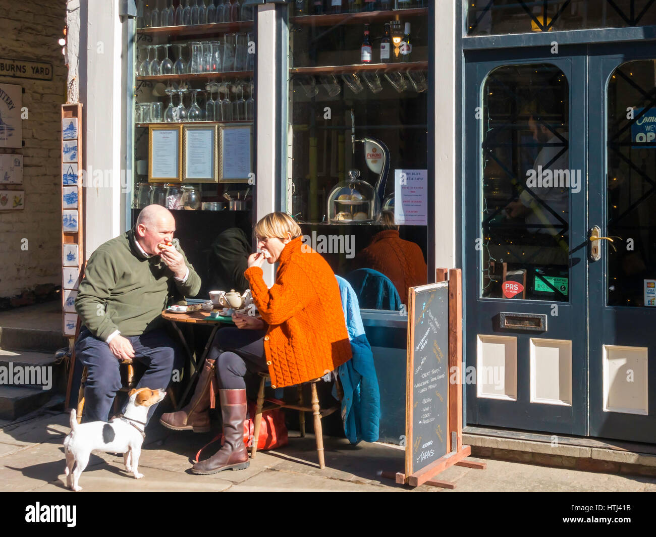 A couple with a Jack Russell dog enjoying lunch in Summmer sunshine at ...