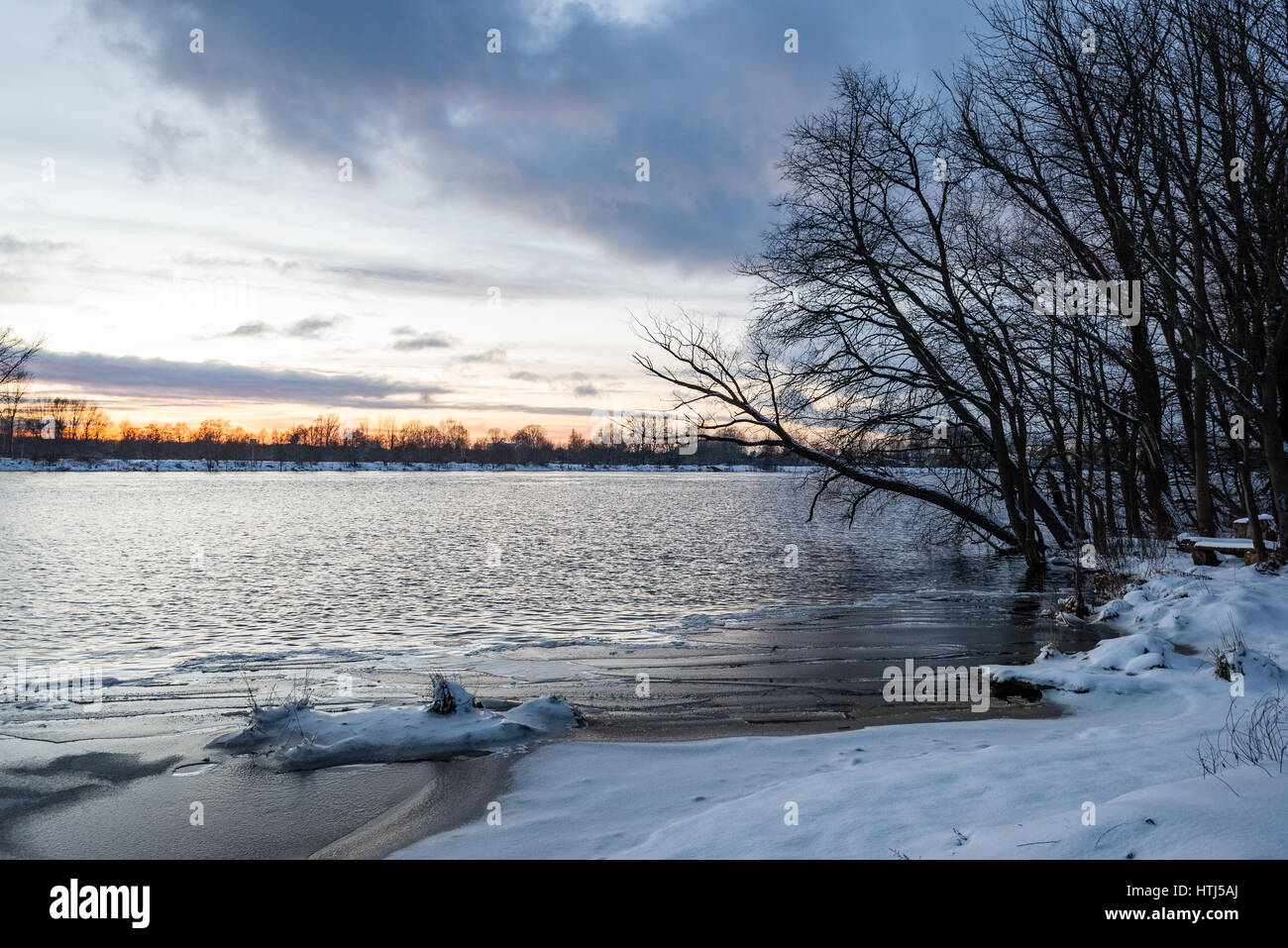frozen countryside scene in winter with snow. iced river with blocks of ...