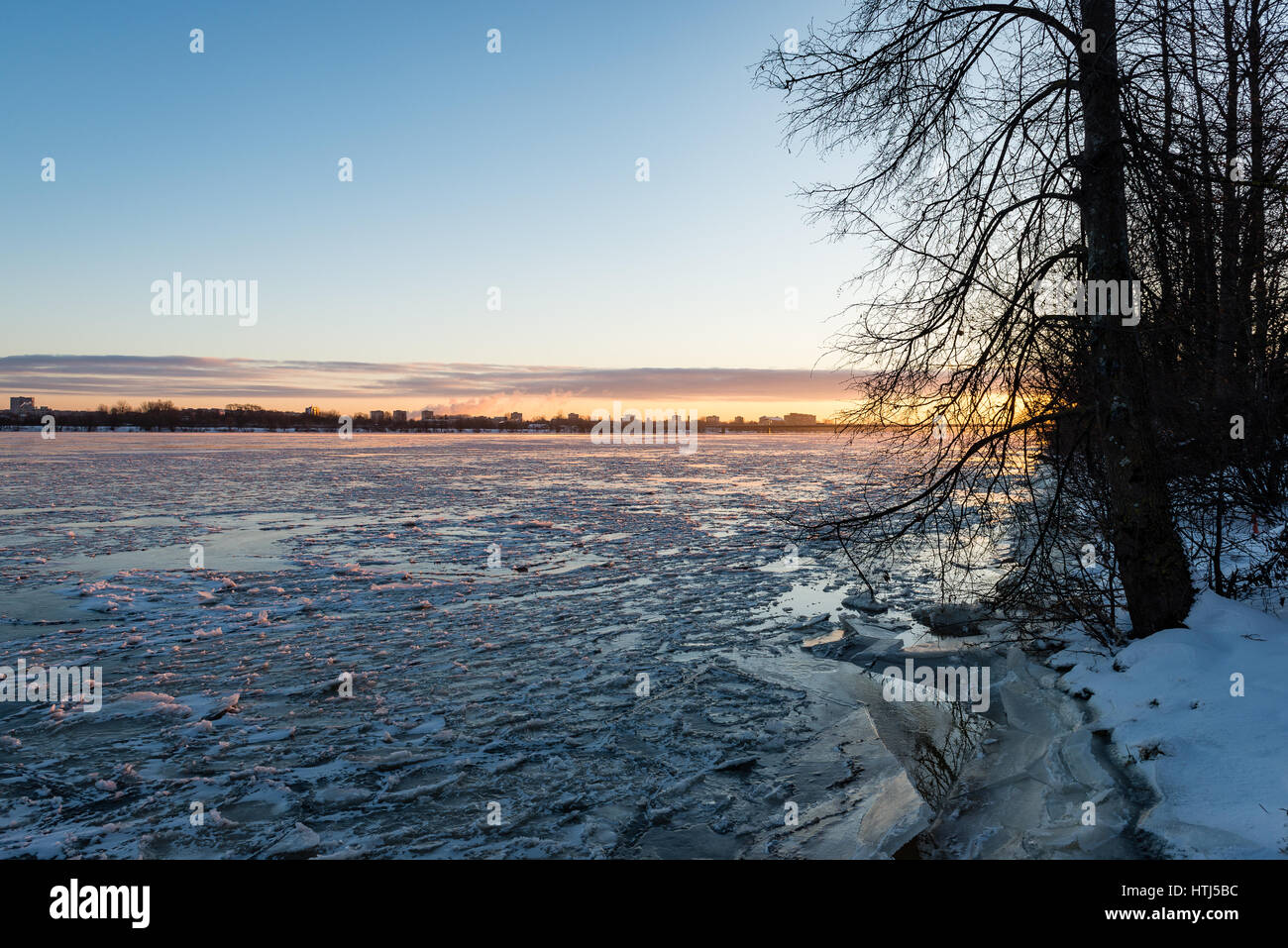 frozen countryside scene in winter with snow. iced river with blocks of ...