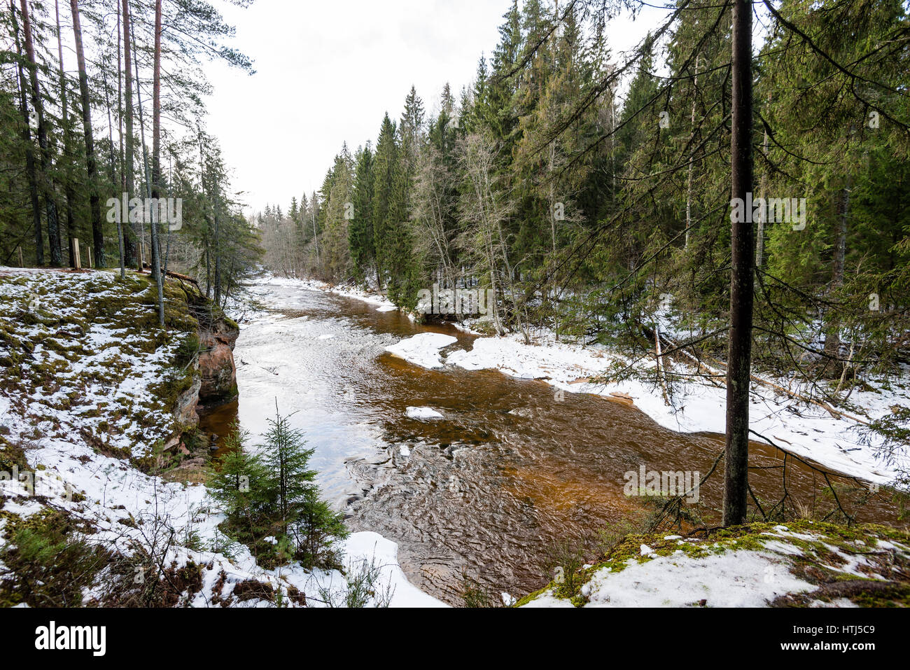 frozen countryside scene in winter with snow. iced river with blocks of ...