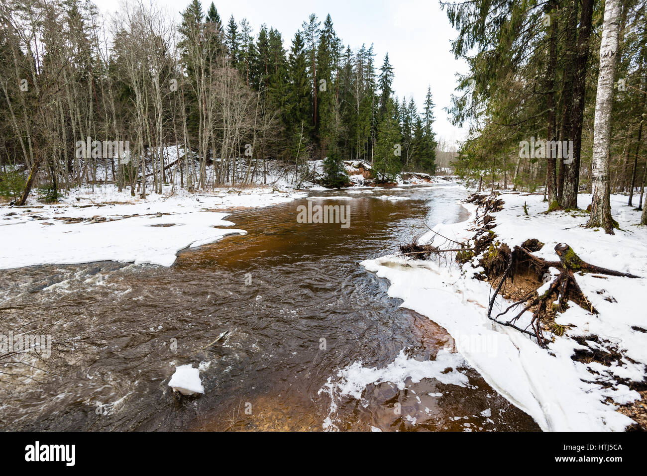 frozen countryside scene in winter with snow. iced river with blocks of ...