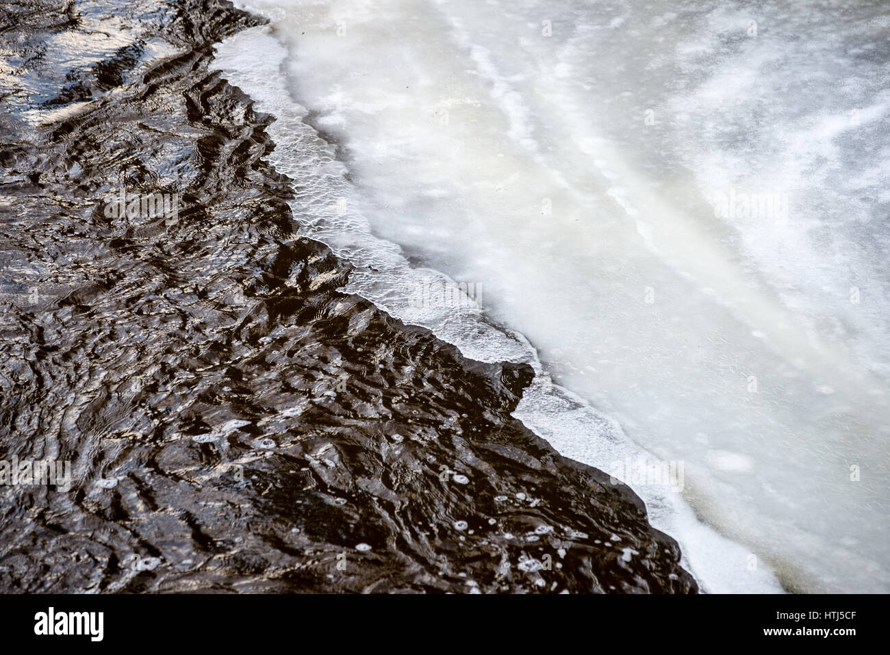 frozen countryside scene in winter with snow. iced river with blocks of ...