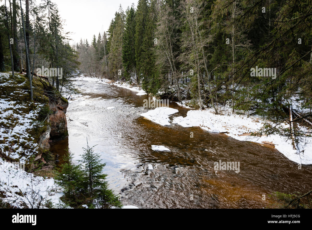 frozen countryside scene in winter with snow. iced river with blocks of ...