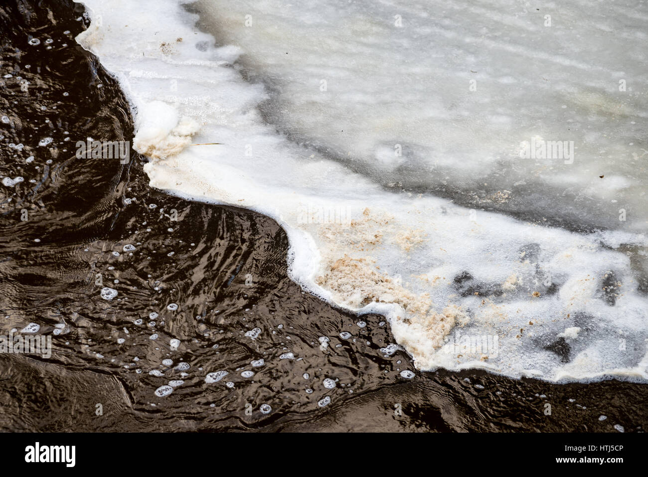 frozen countryside scene in winter with snow. iced river with blocks of ...