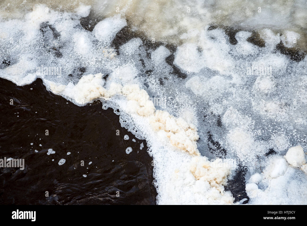 frozen countryside scene in winter with snow. iced river with blocks of ...