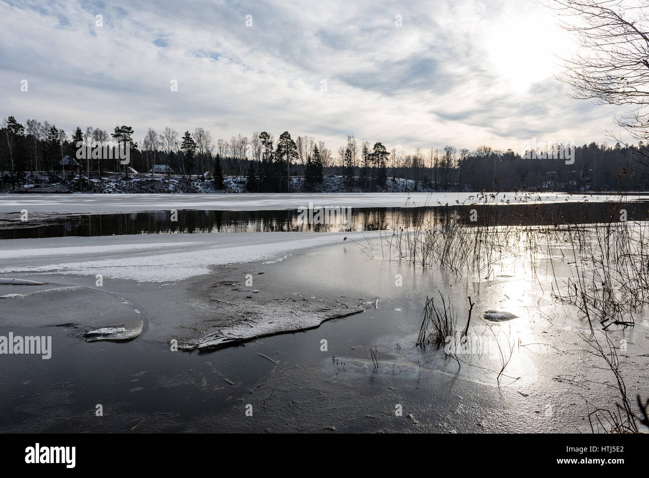 frozen countryside scene in winter with snow. iced river with blocks of ...