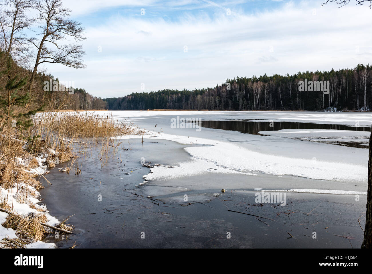 frozen countryside scene in winter with snow. iced river with blocks of ...