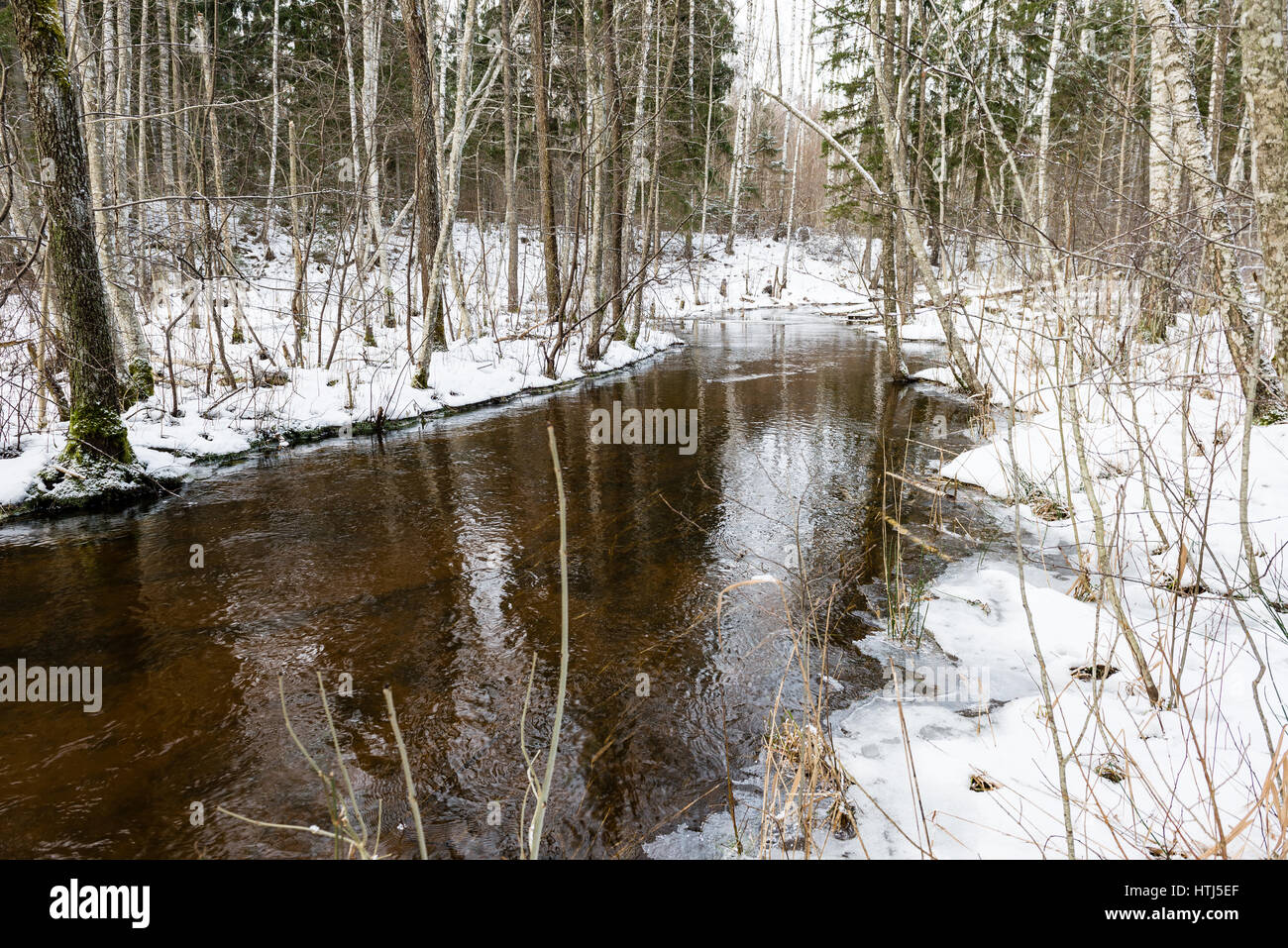 frozen countryside scene in winter with snow. iced river with blocks of ...