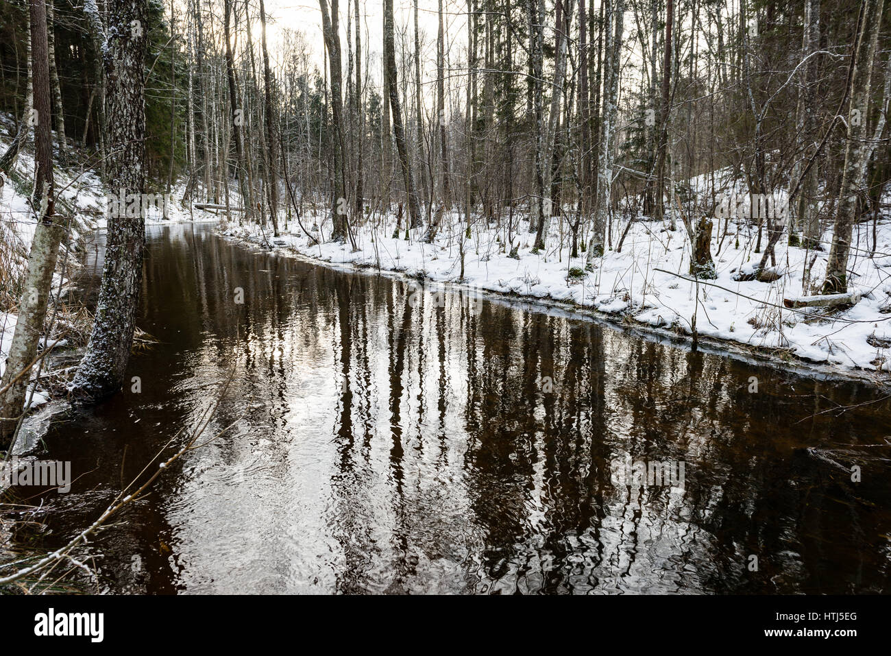 frozen countryside scene in winter with snow. iced river with blocks of ...