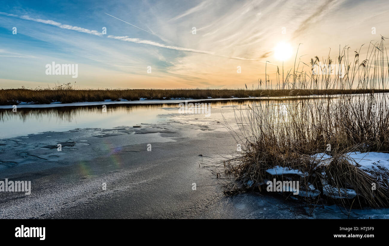 frozen countryside scene in winter with snow. iced river with blocks of ...