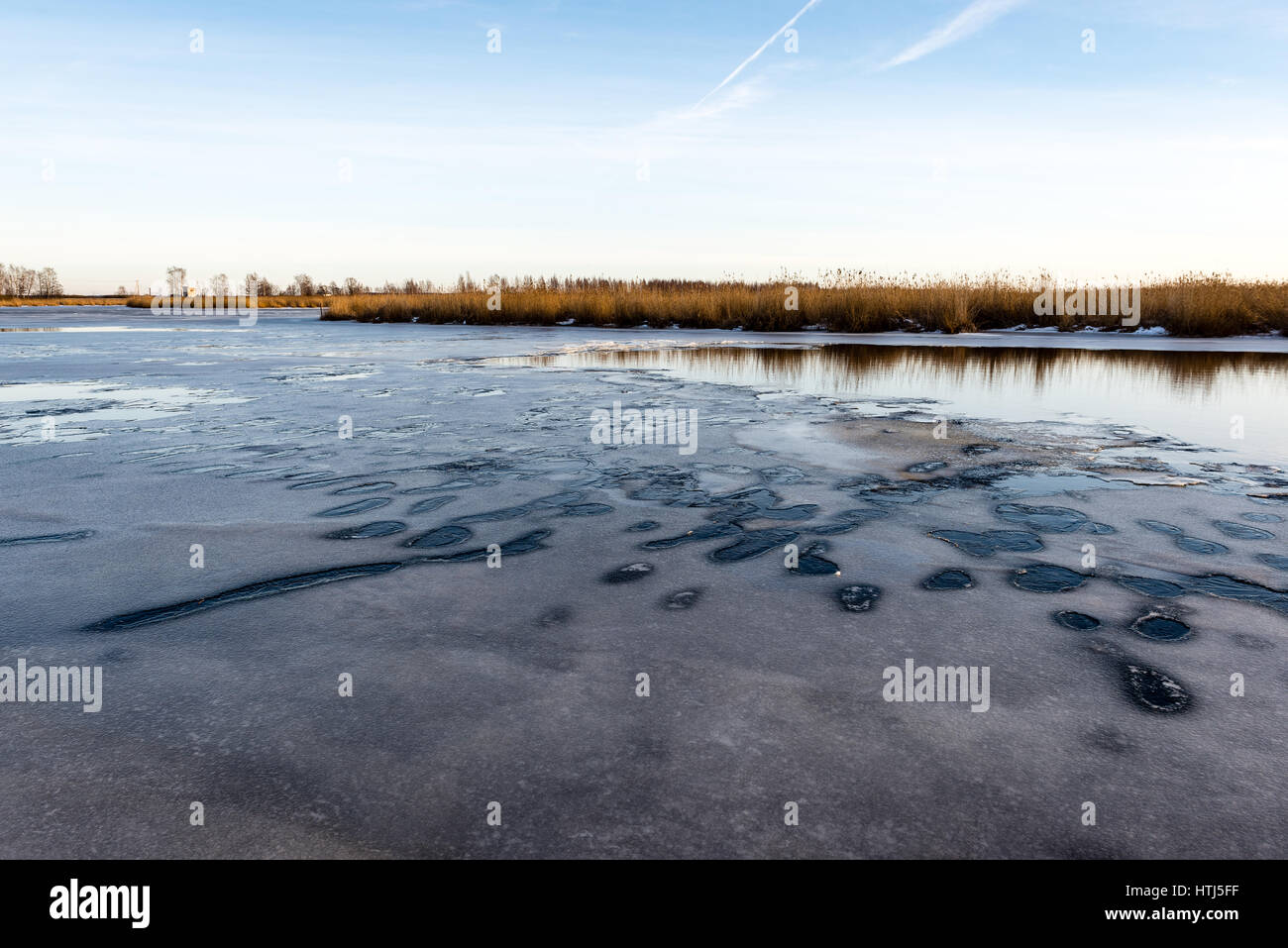 frozen countryside scene in winter with snow. iced river with blocks of ...