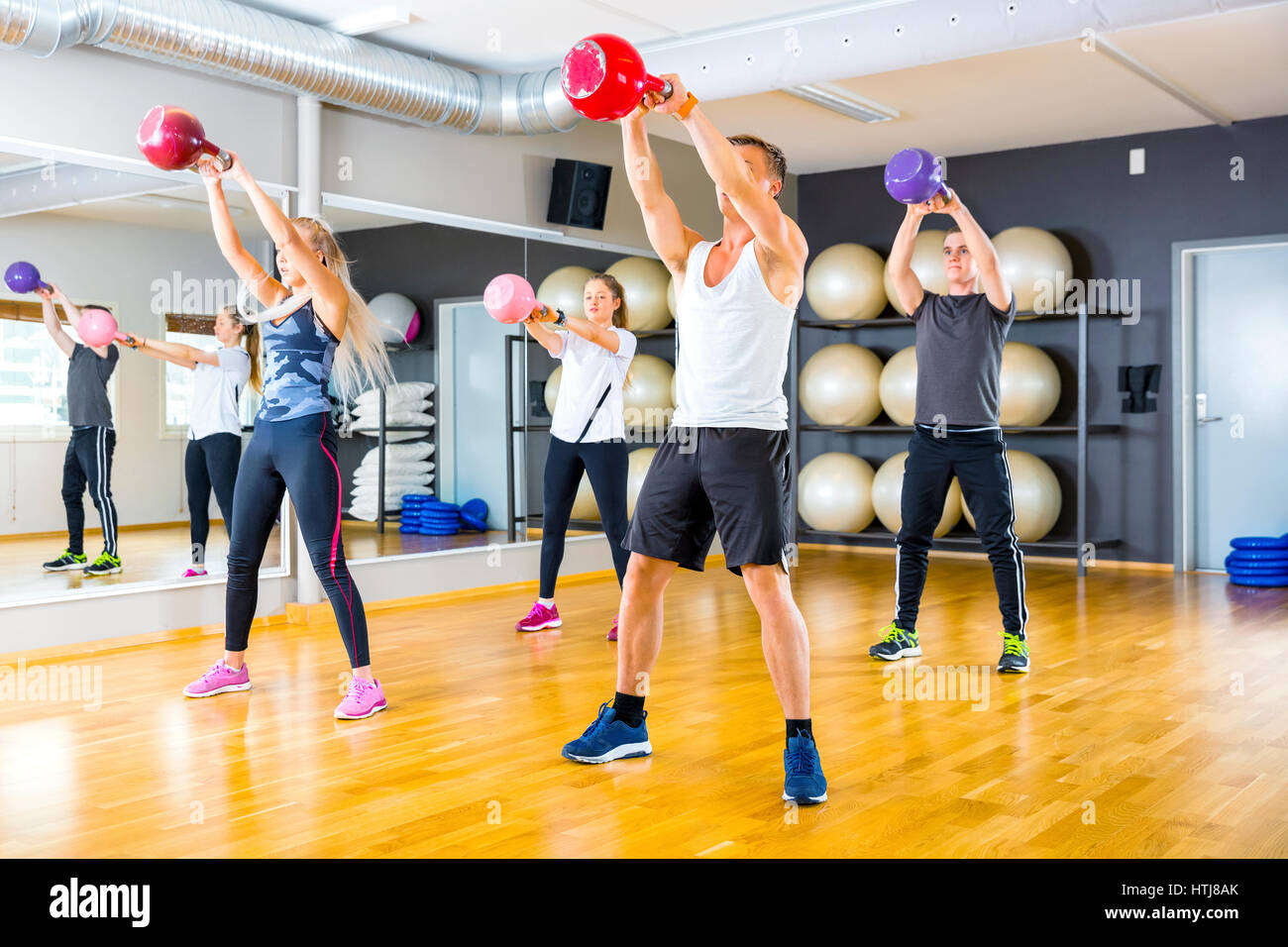 Focused team trains with kettlebells at fitness gym Stock Photo - Alamy