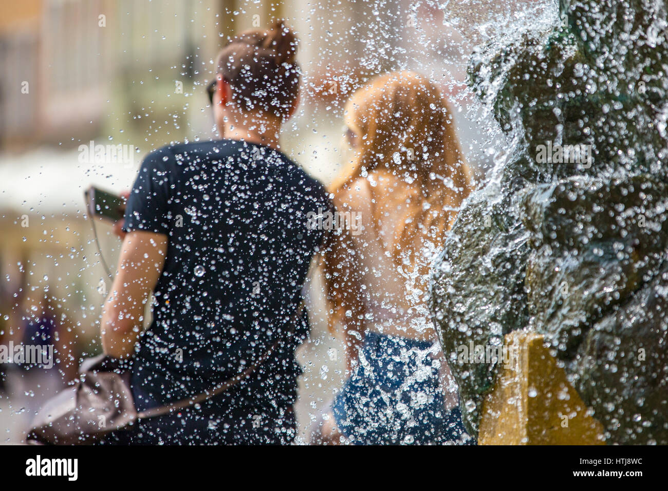 Love, young couple hugging each other behind water drops from a ...