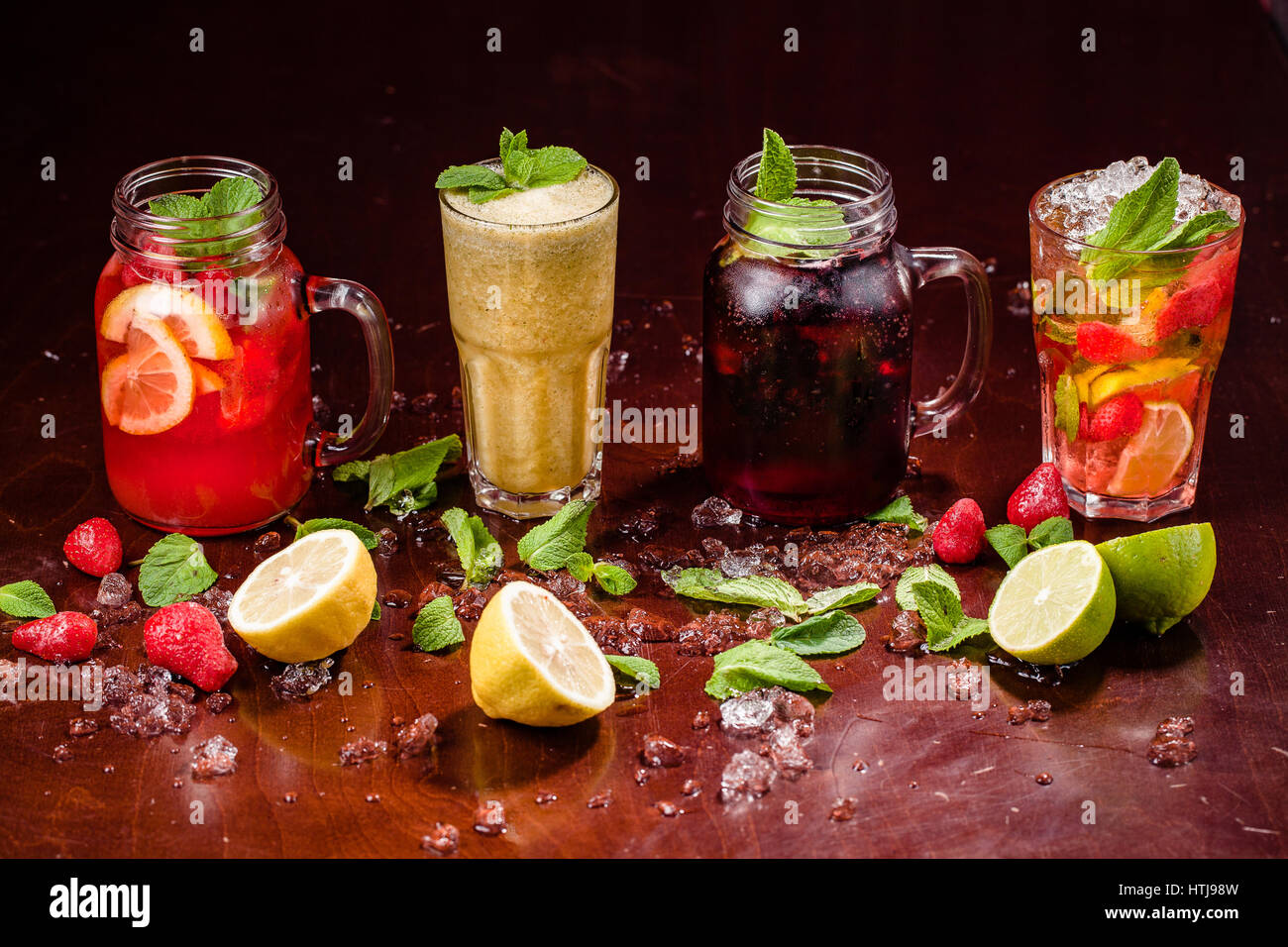 Coctails in a glass with raw fruits on wooden table with crashed ice ...