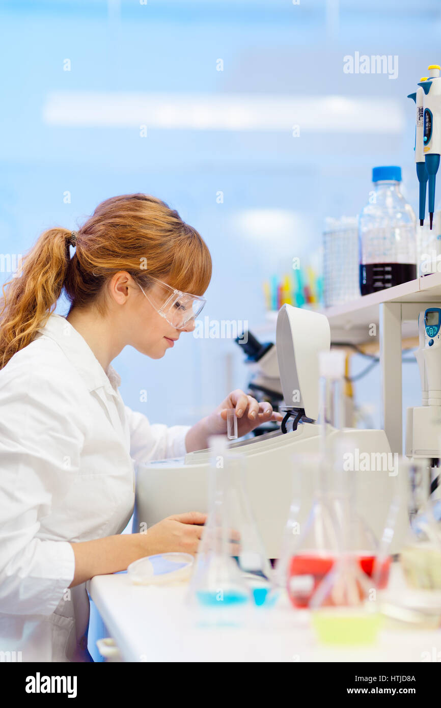 Attractive young scientist pipetting Stock Photo - Alamy