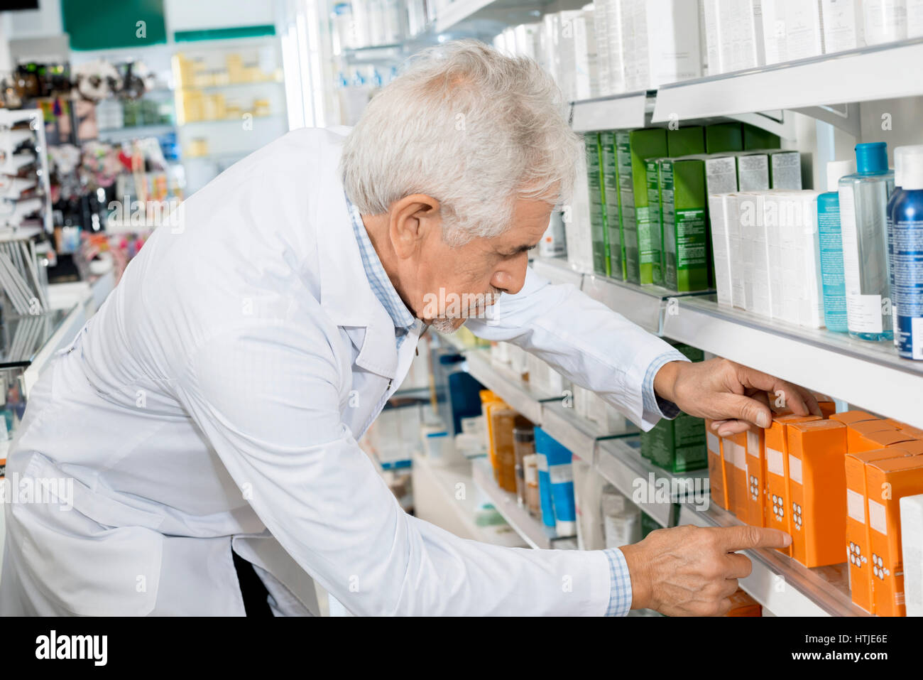 Male Pharmacist Arranging Medicines On Shelf In Pharmacy Stock Photo ...