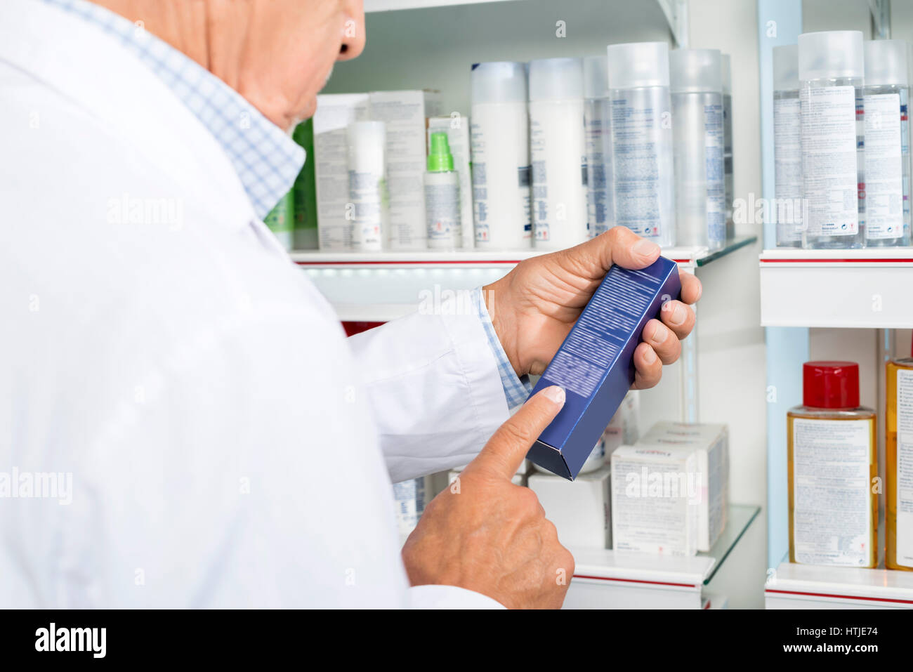 Midsection Of Pharmacist Reading Instructions On Medicine Box Stock ...