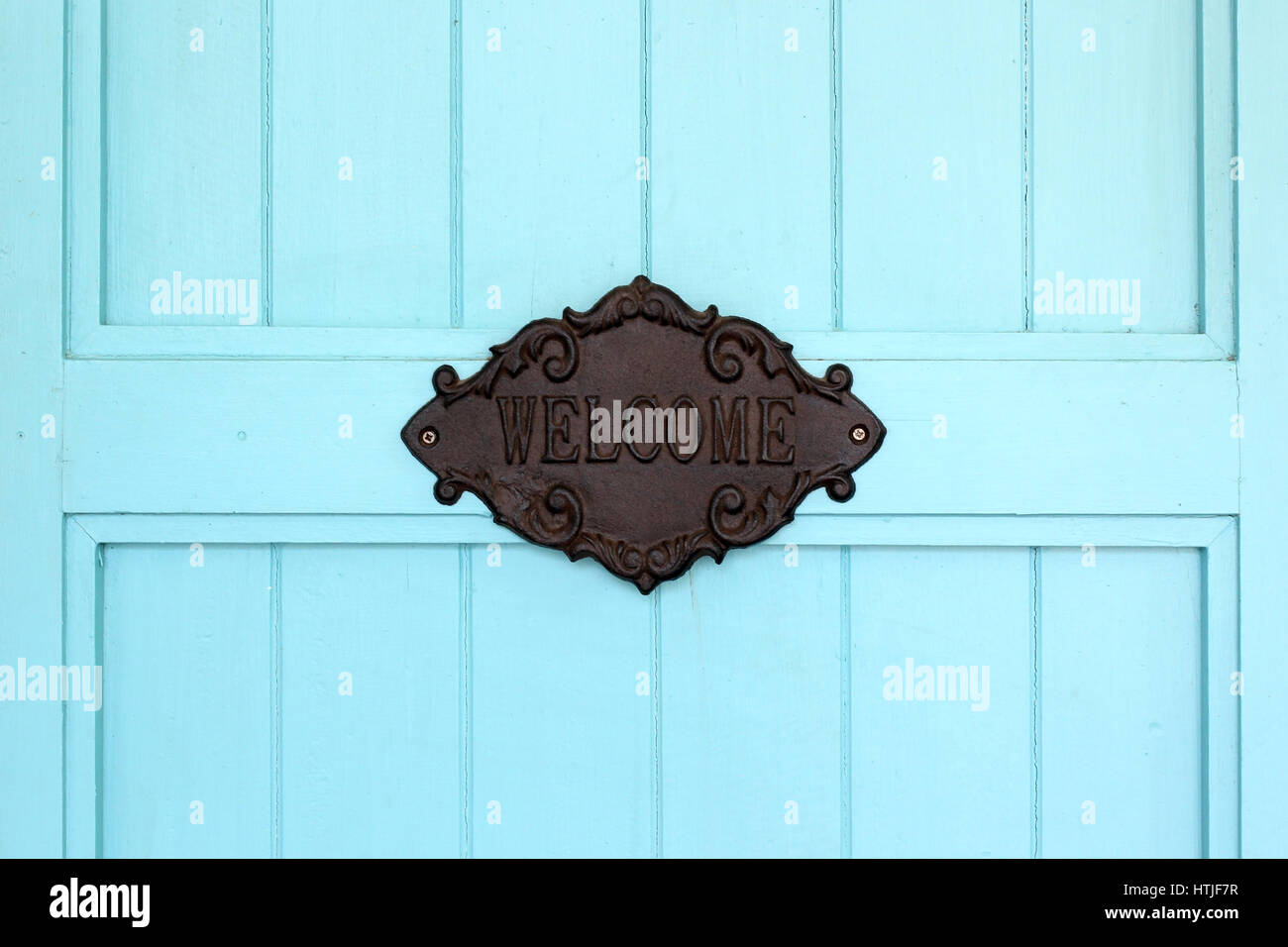 vintage welcome sign on blue wooden door Stock Photo - Alamy