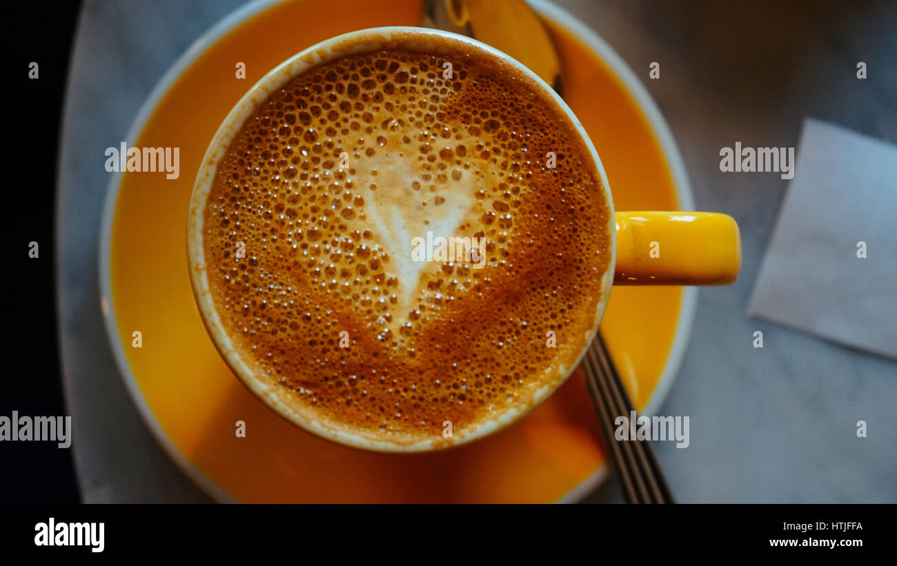 A hear formed with milk in an orange cup of coffee Stock Photo - Alamy