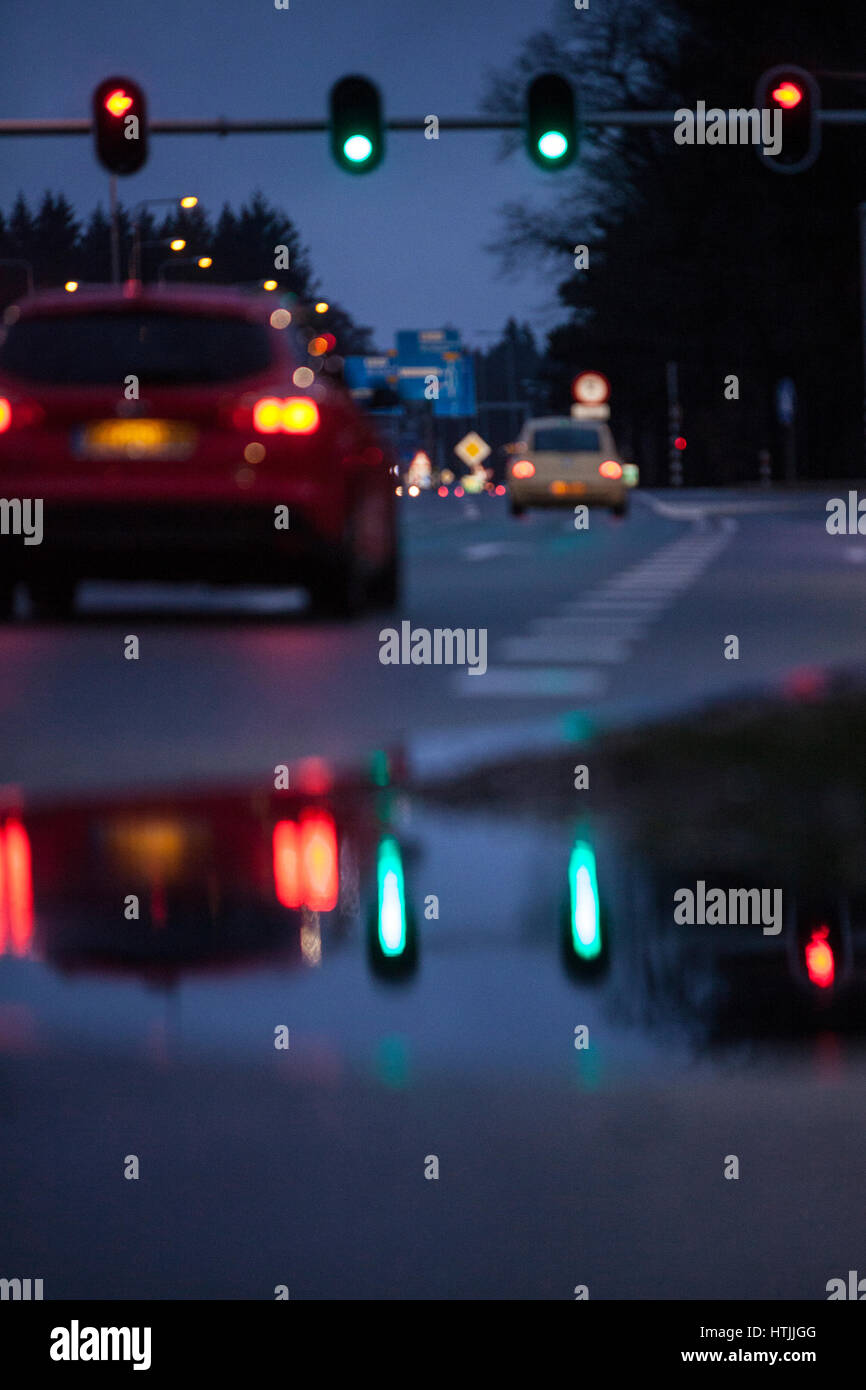 cars and traffic lights during rush hour in the dark reflected in ...