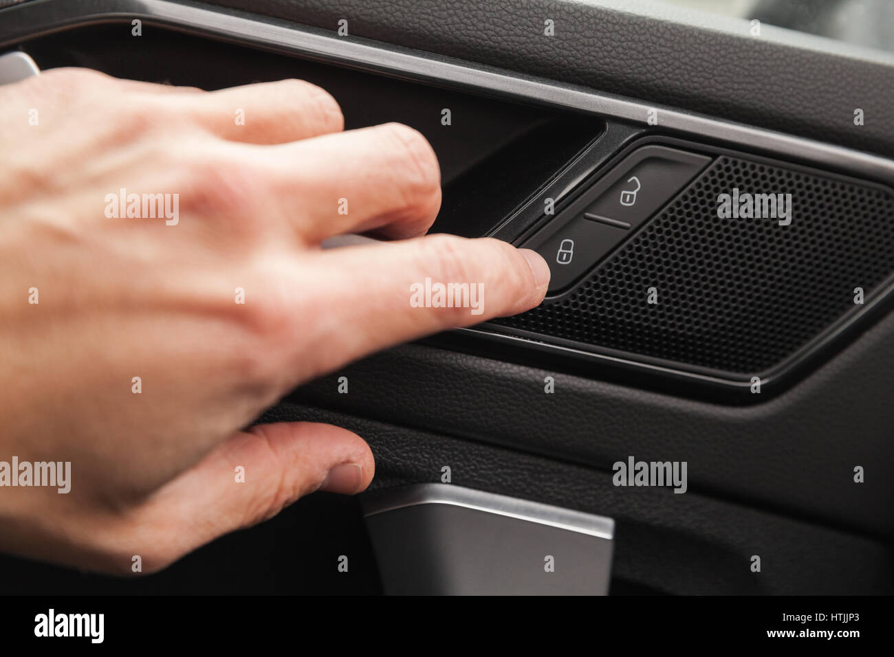 Driver hand pushes door lockers button of luxury crossover car. Close ...