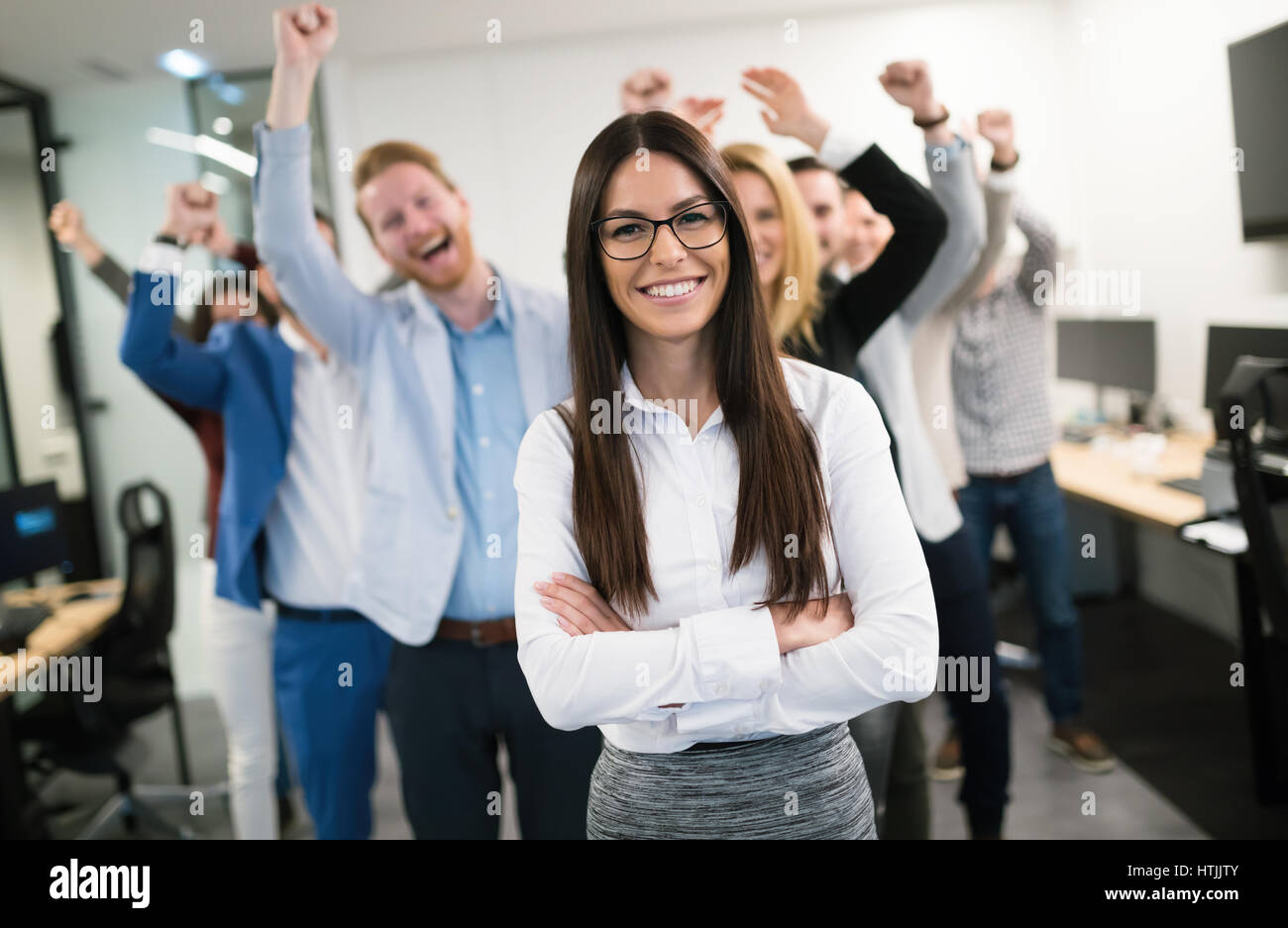 Happy business people celebrating success at company Stock Photo - Alamy