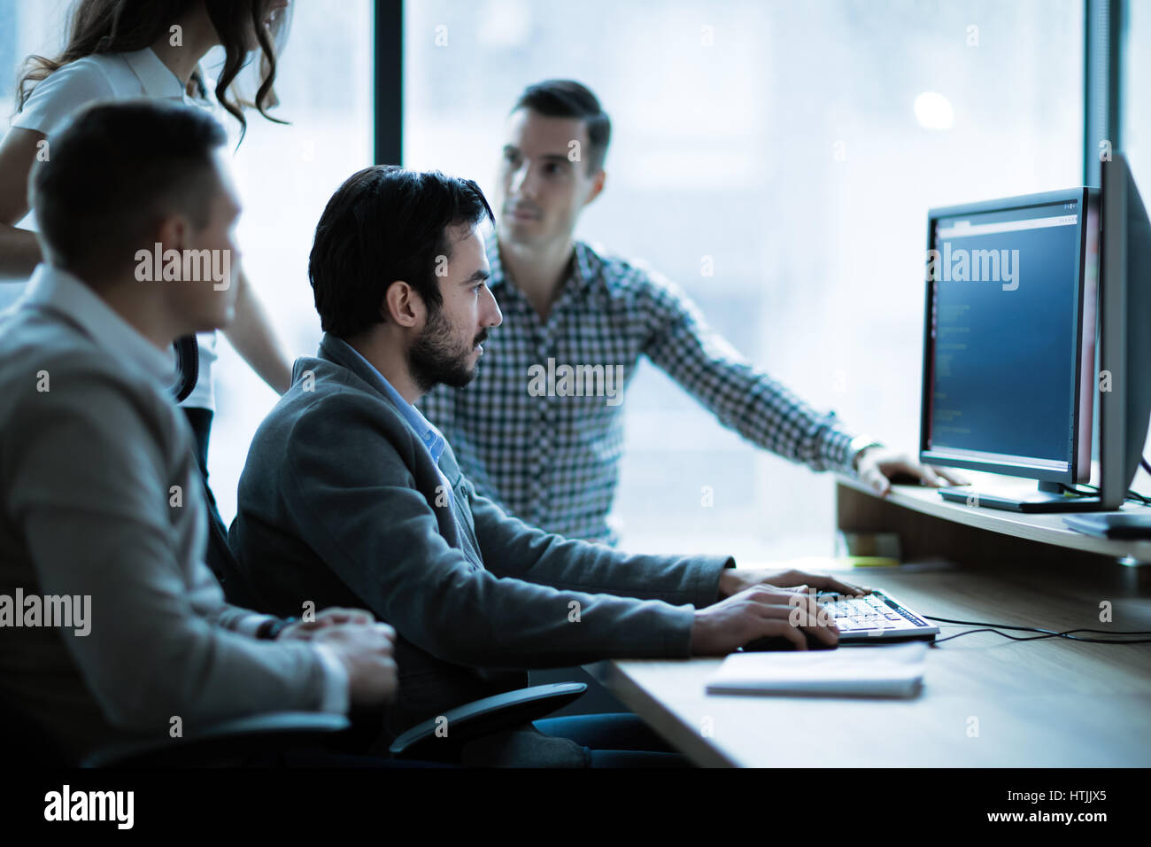Coworkers working on project together in company office Stock Photo - Alamy
