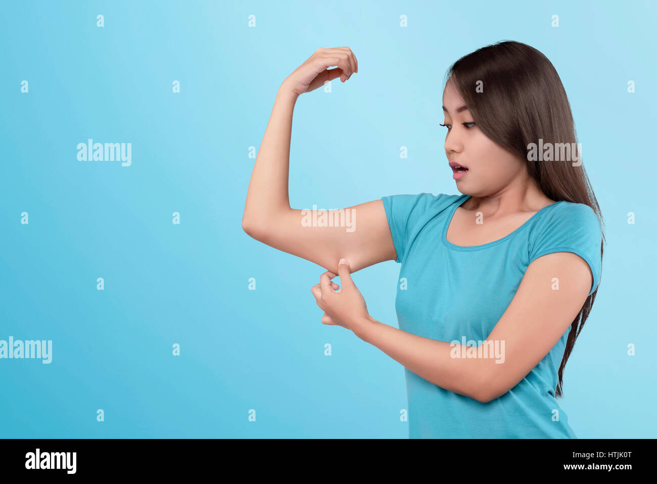 Young asian woman losing muscle on her arm on blue background Stock ...