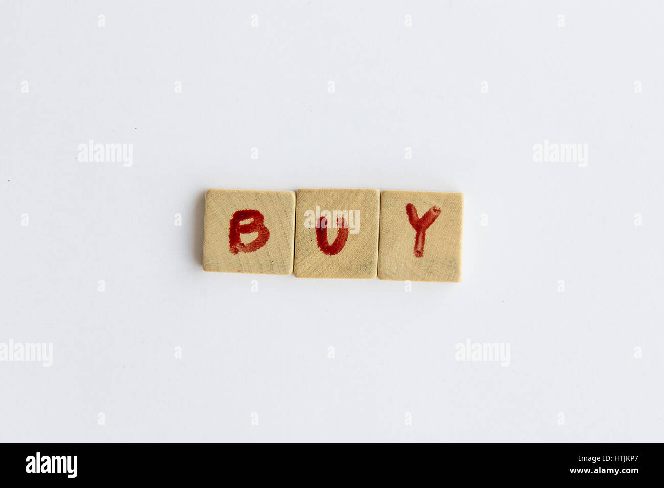 the word Buy formed with letters written on squares of wood dowels ...