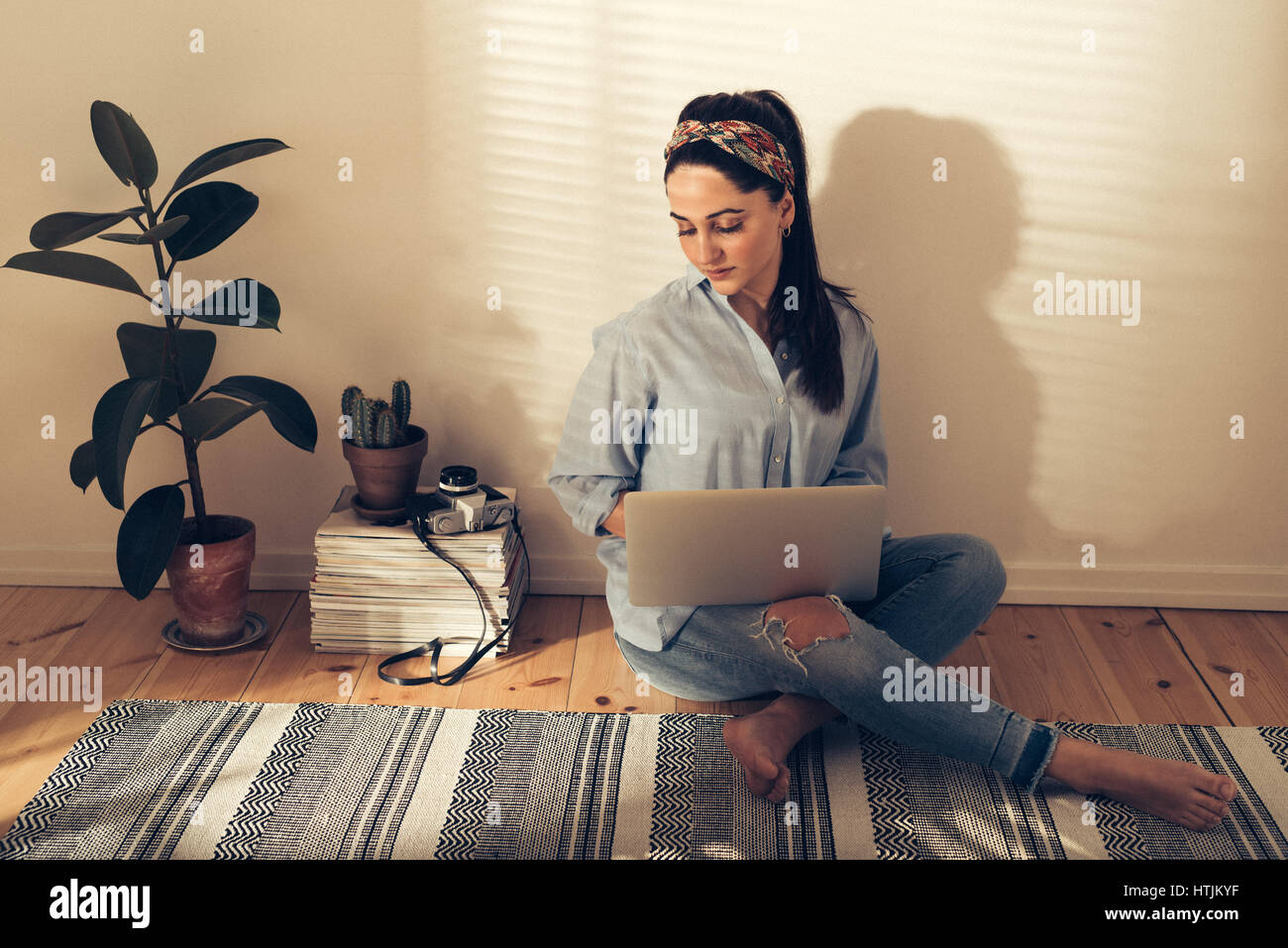 Pretty hipster young woman in tatty denim designer jeans sitting ...
