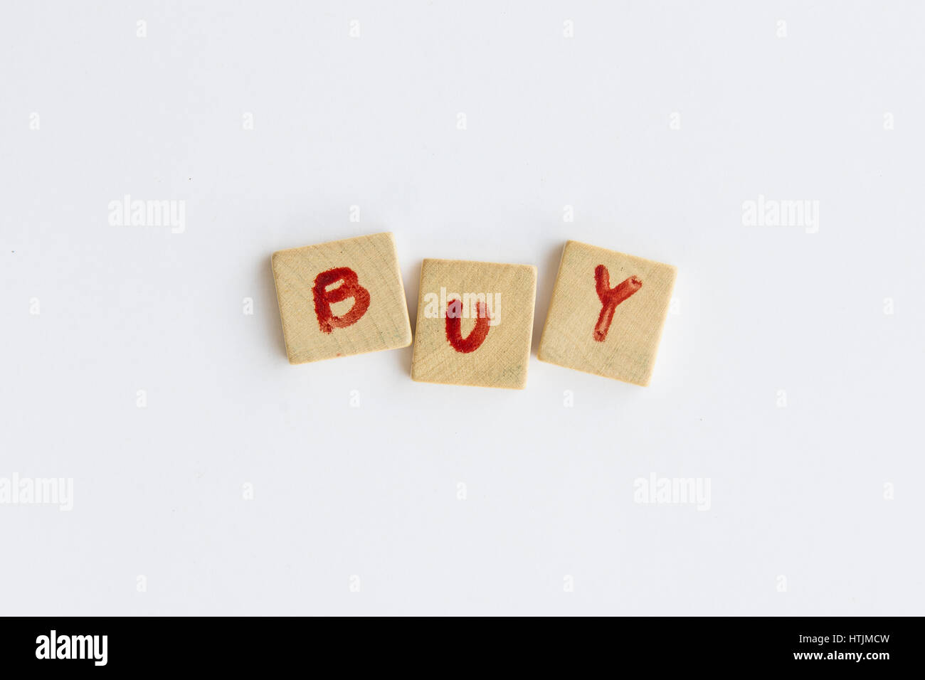 the word Buy formed with letters written on squares of wood dowels ...