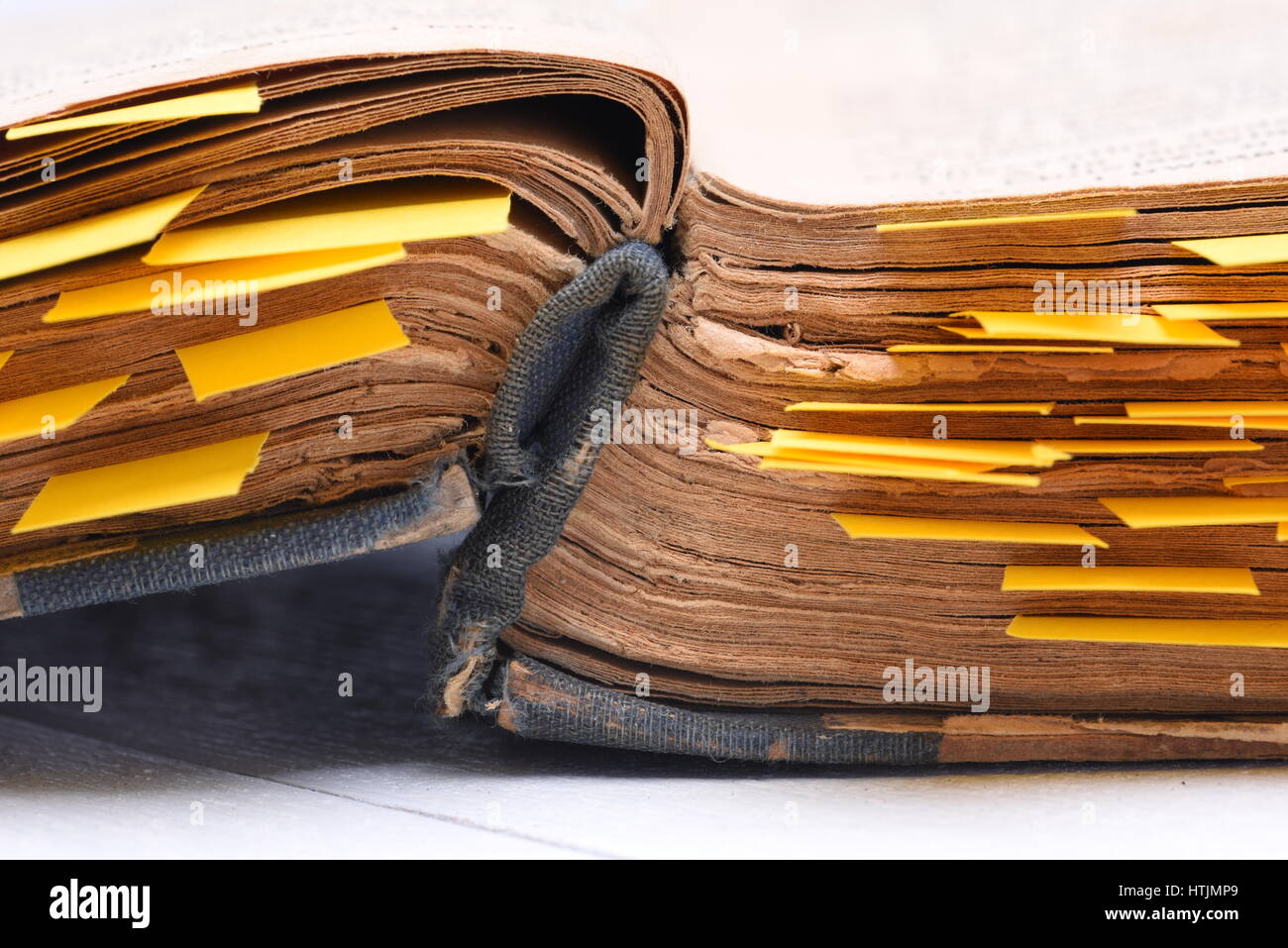 Old open book with paper bookmarks on desk close up Stock Photo - Alamy