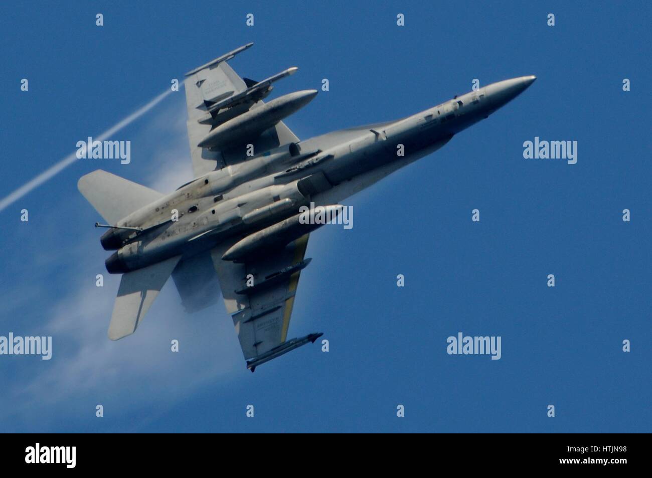 A U.S. Navy F/A-18C Hornet jet aircraft performs a high-speed turn in ...
