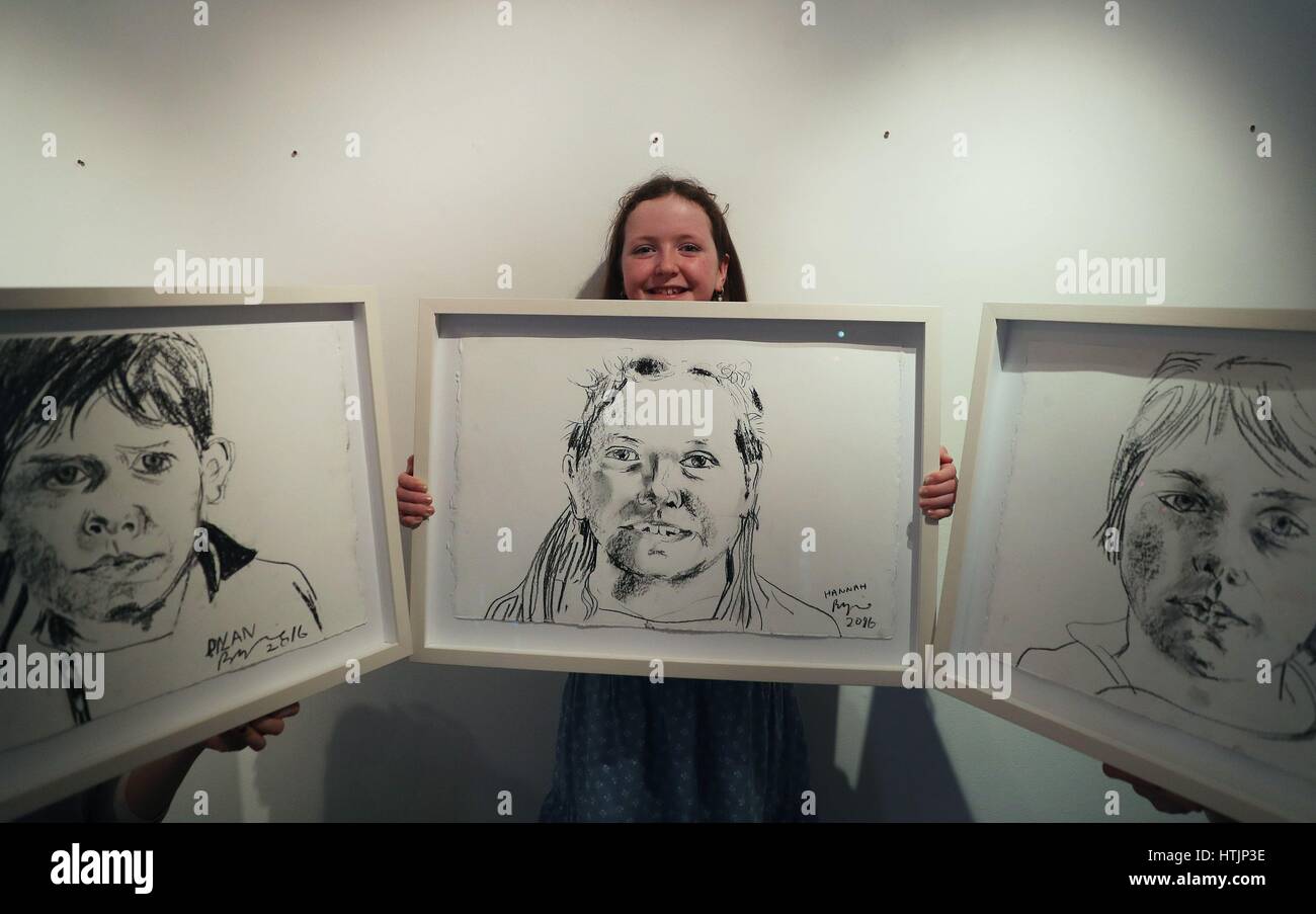 Hannah McNally, 10, from Bray holds her portrait at the opening of a ...
