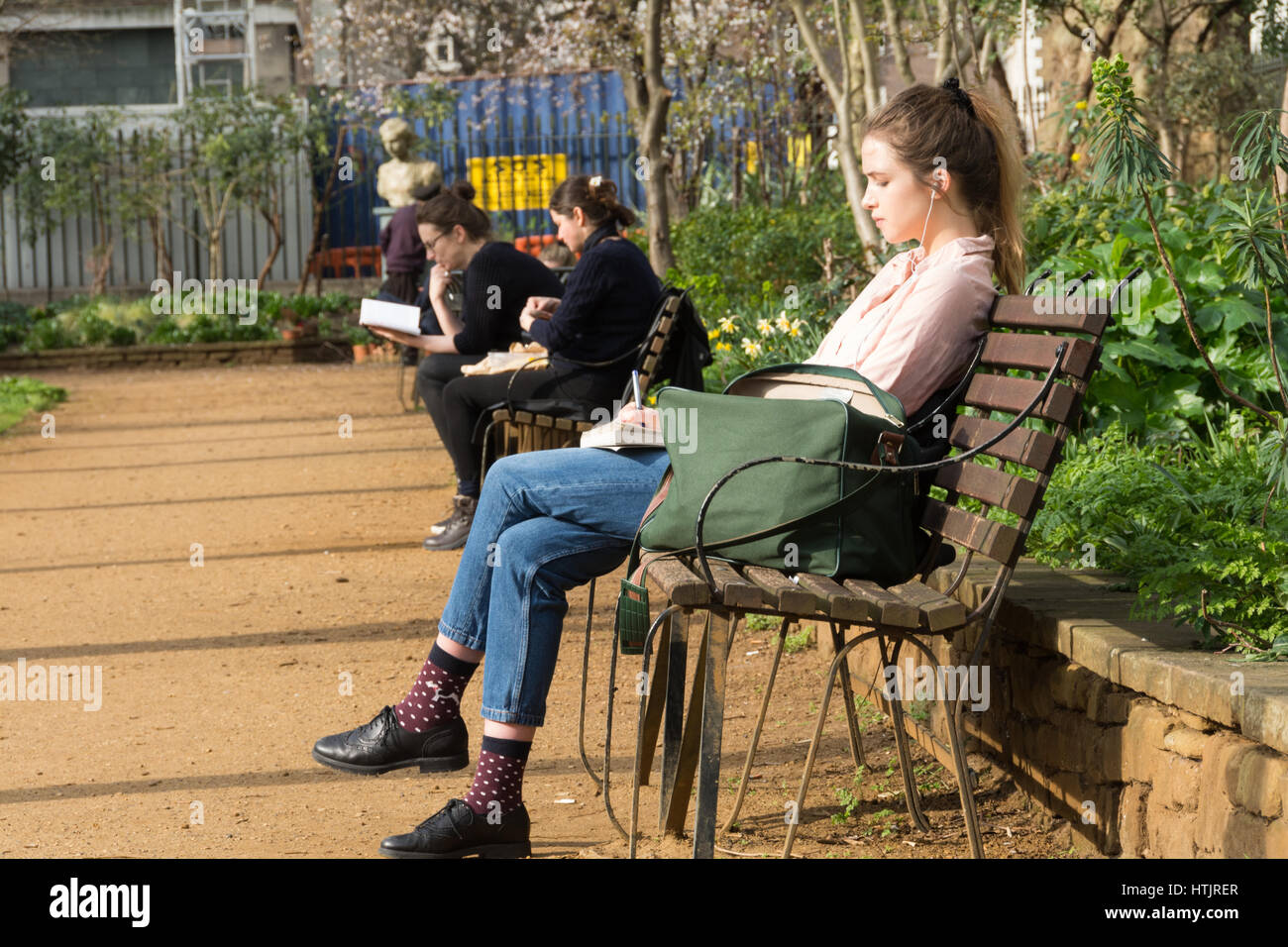 Students sitting in the spring sunshine in Gordon Square, London, UK ...