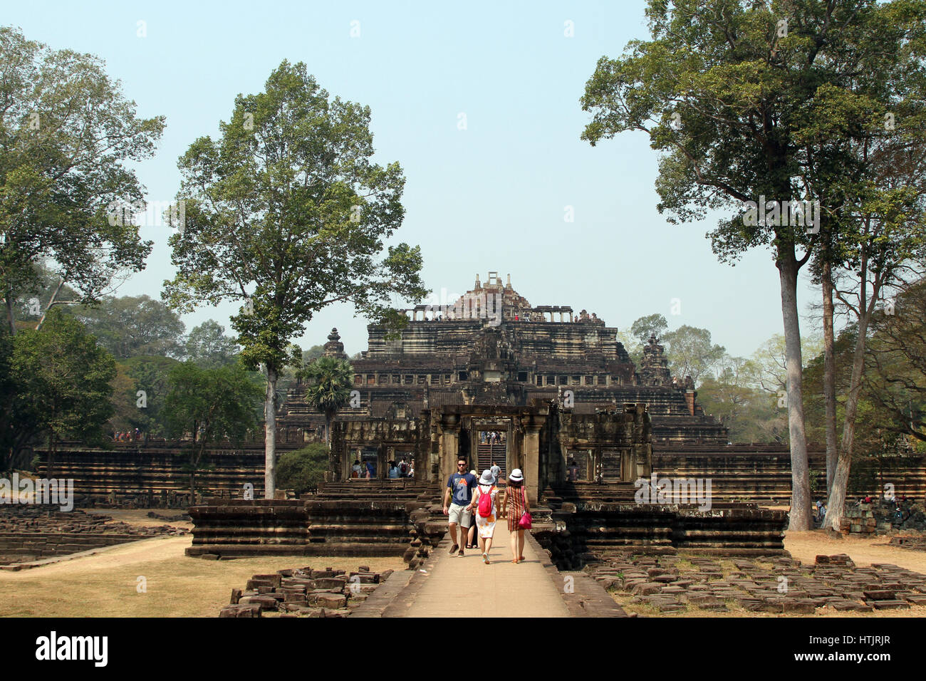 Tourists walk towards the Baphuon temple in Angkor Thom, the former ...