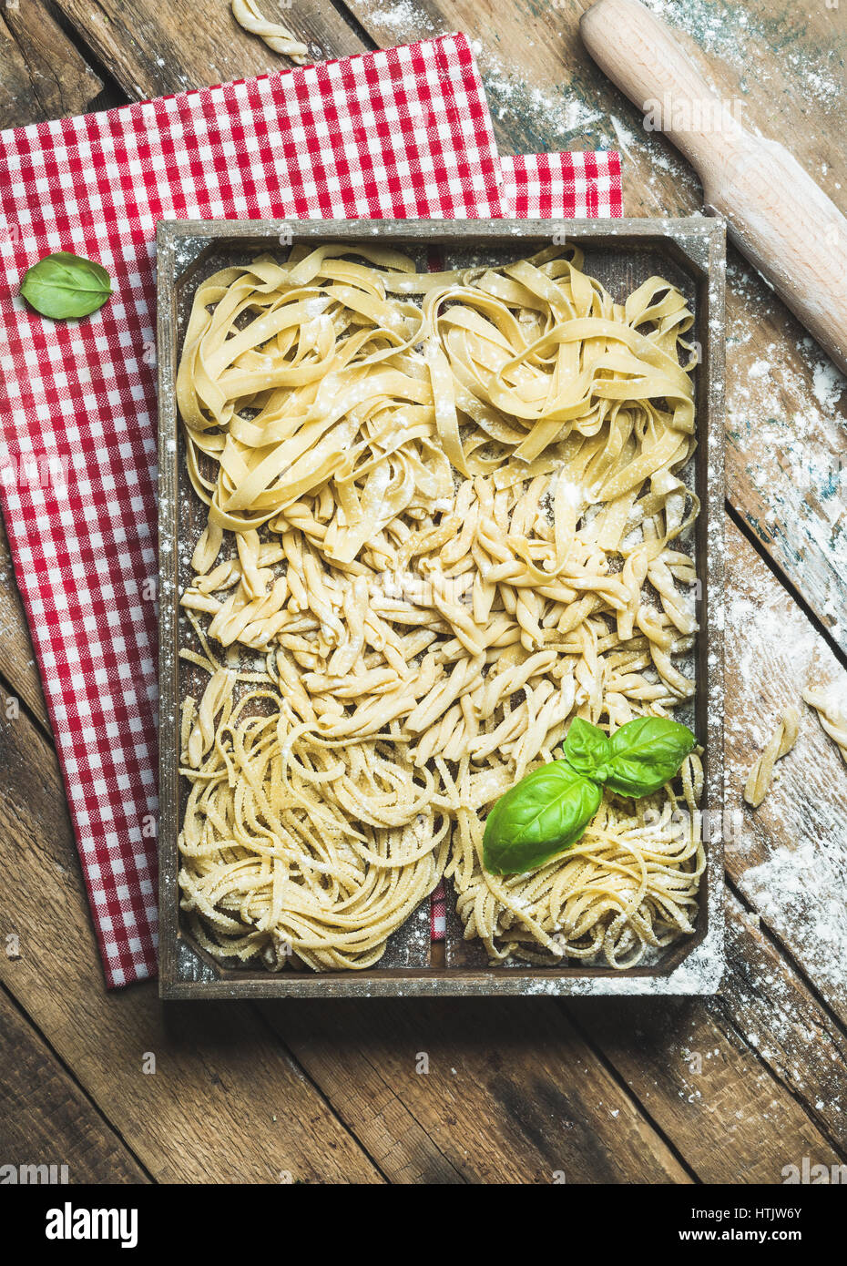 Uncooked Italian pasta in wooden tray over rustic background Stock ...