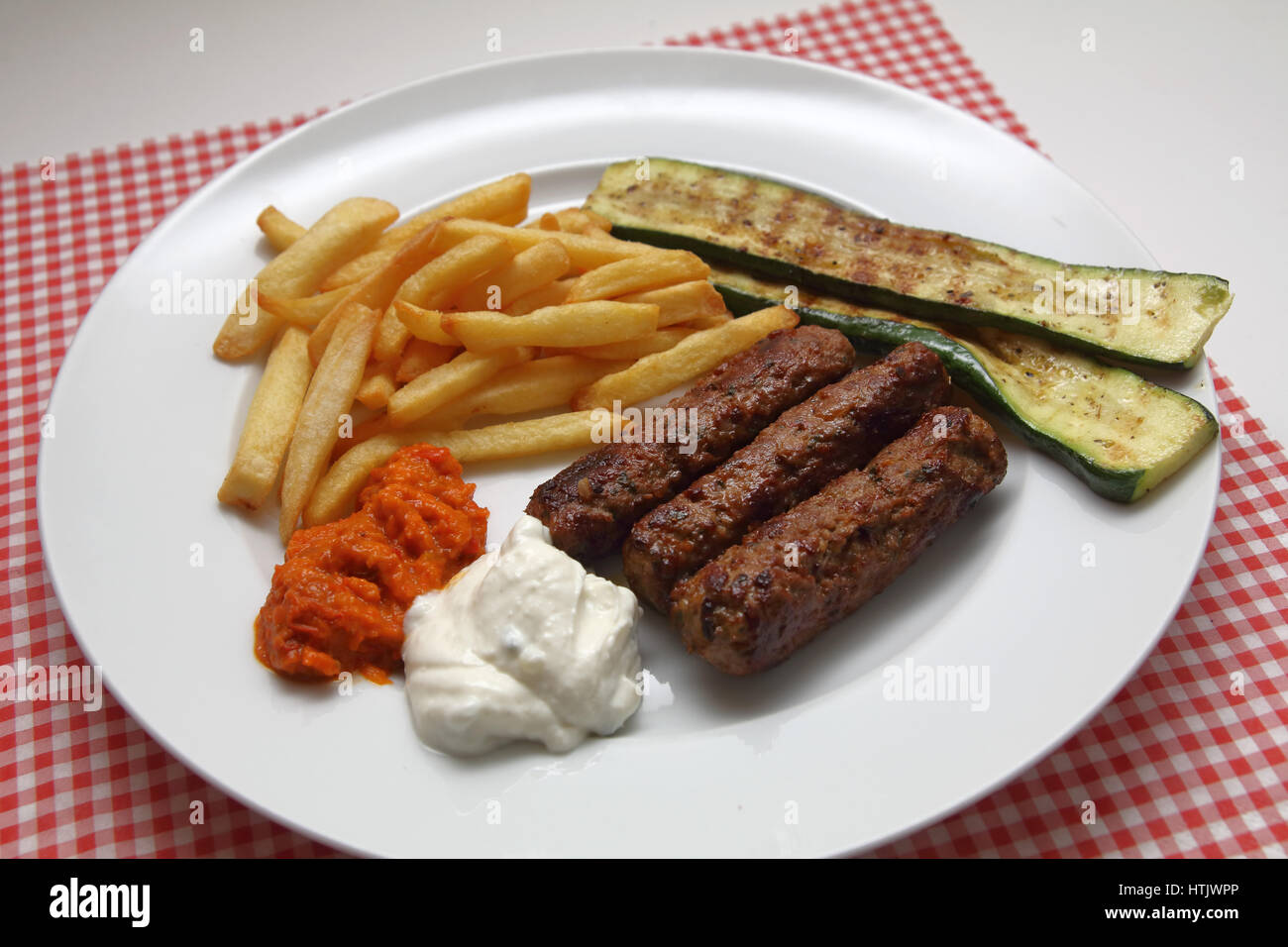 Cevapcici mit Pommes frites, Zucchini, Ajvar und Tzatziki Stock Photo ...