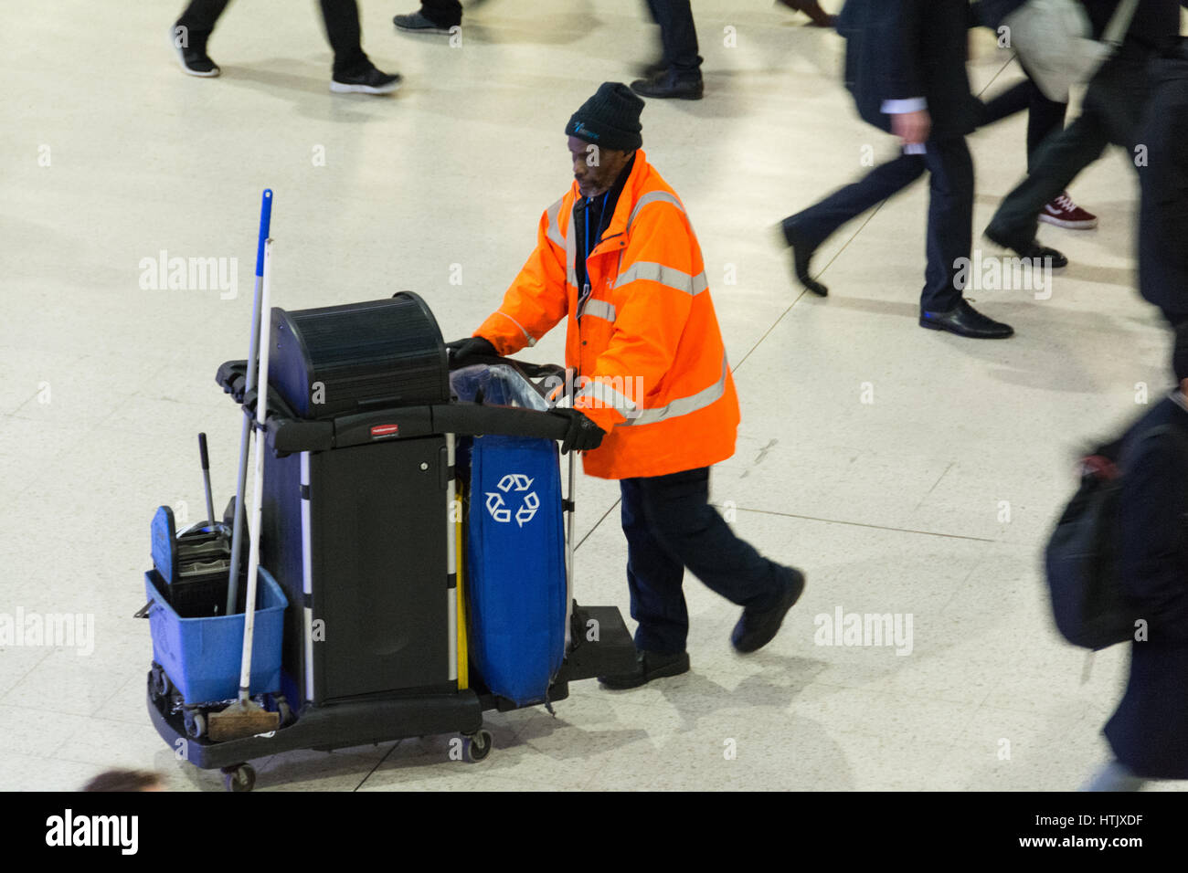 An elderly station cleaner at Waterloo Station during rush-hour, London ...