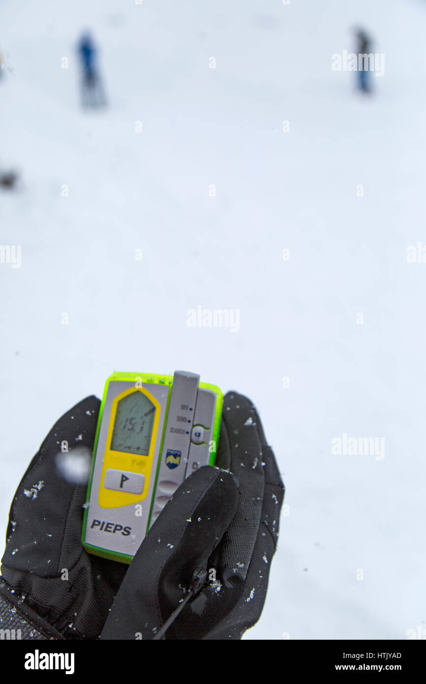Person using a Pieps avalanche transceiver in snowy mountains. Close up ...