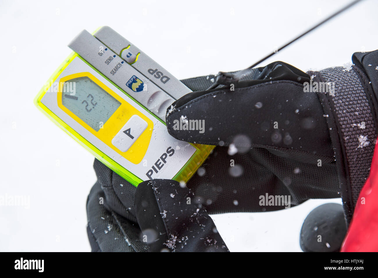 Person using a Pieps avalanche transceiver in snowy mountains. Close up ...