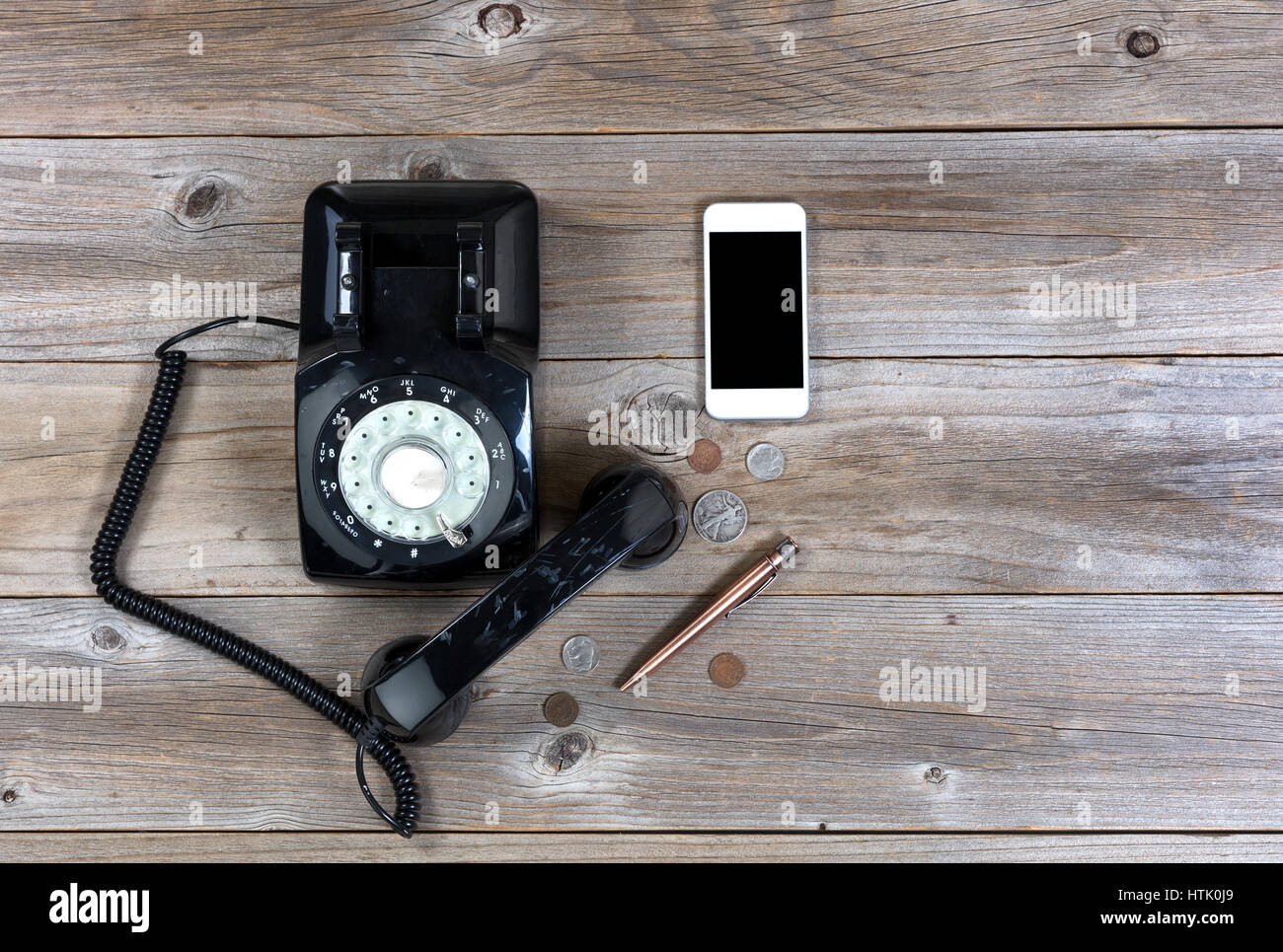 Overhead view of antique phone with modern smartphone on rustic wood ...