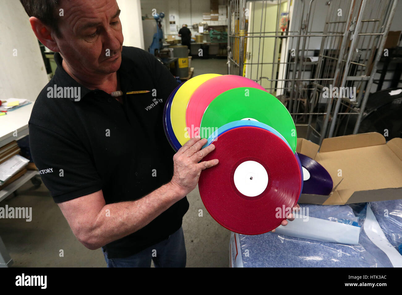 A press room operative looks through a selection of coloured vinyl ...