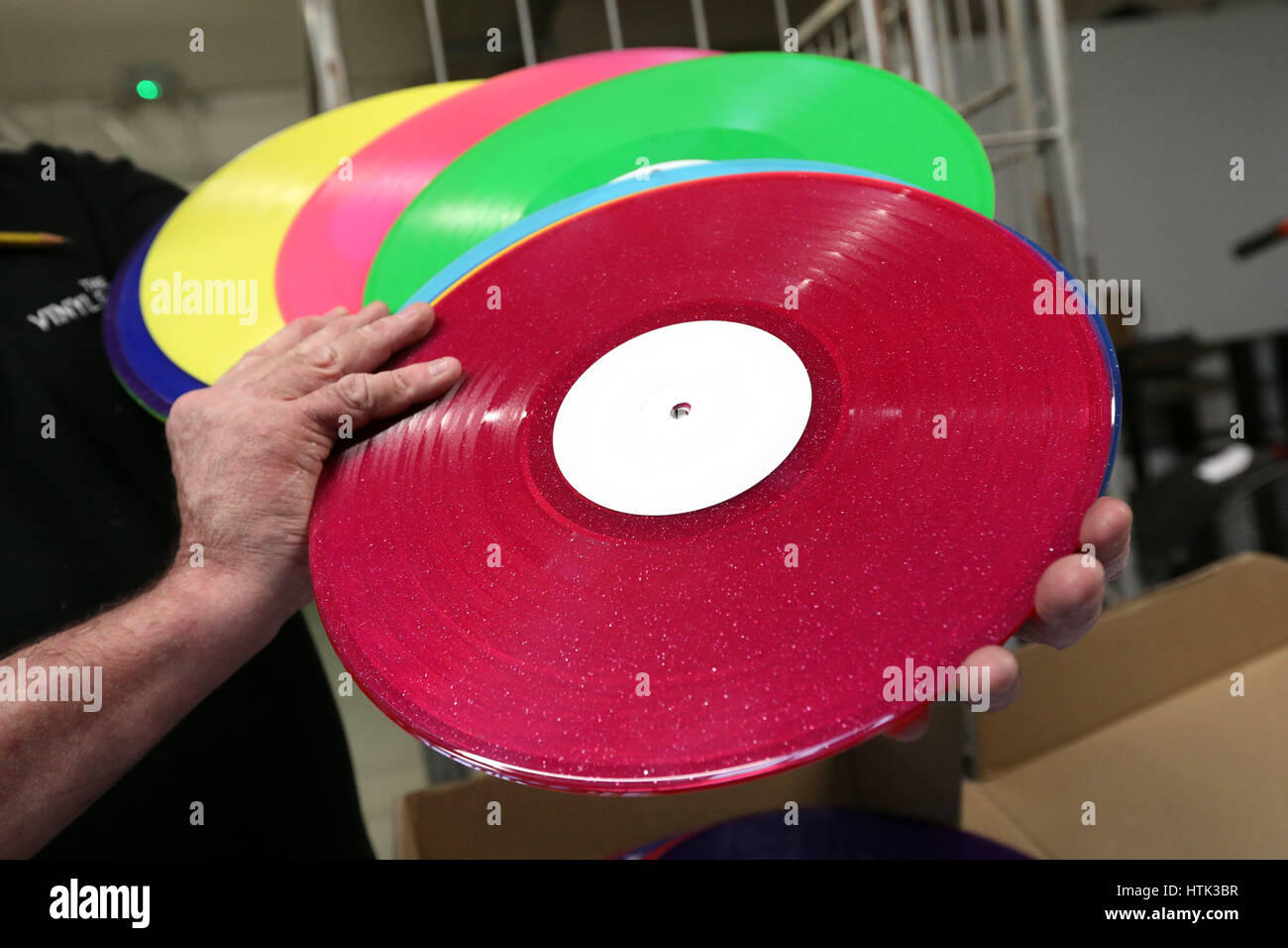 A press room operative looks through a selection of coloured vinyl ...