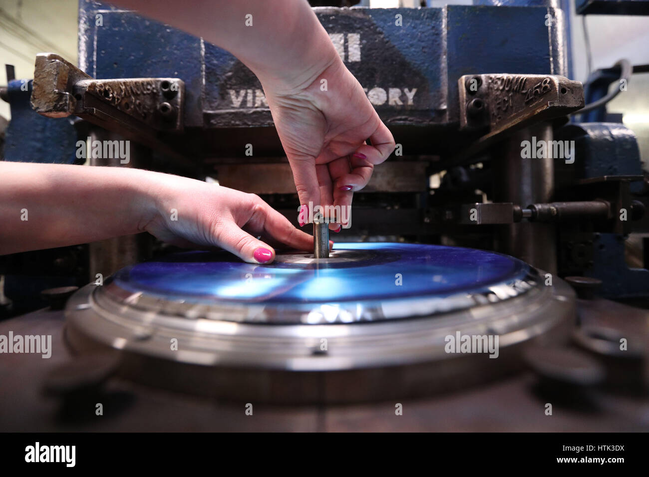 A press room operative prepares a stamper before it goes into the vinyl ...