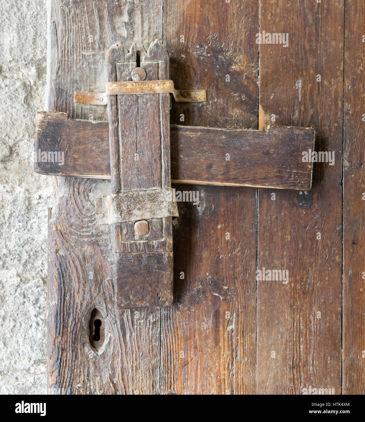 Front view closeup of a wooden aged latch, and keyhole over a wooden ...