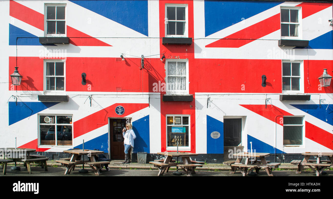 Woman standing having a drink outside a pub painted with a union jack ...