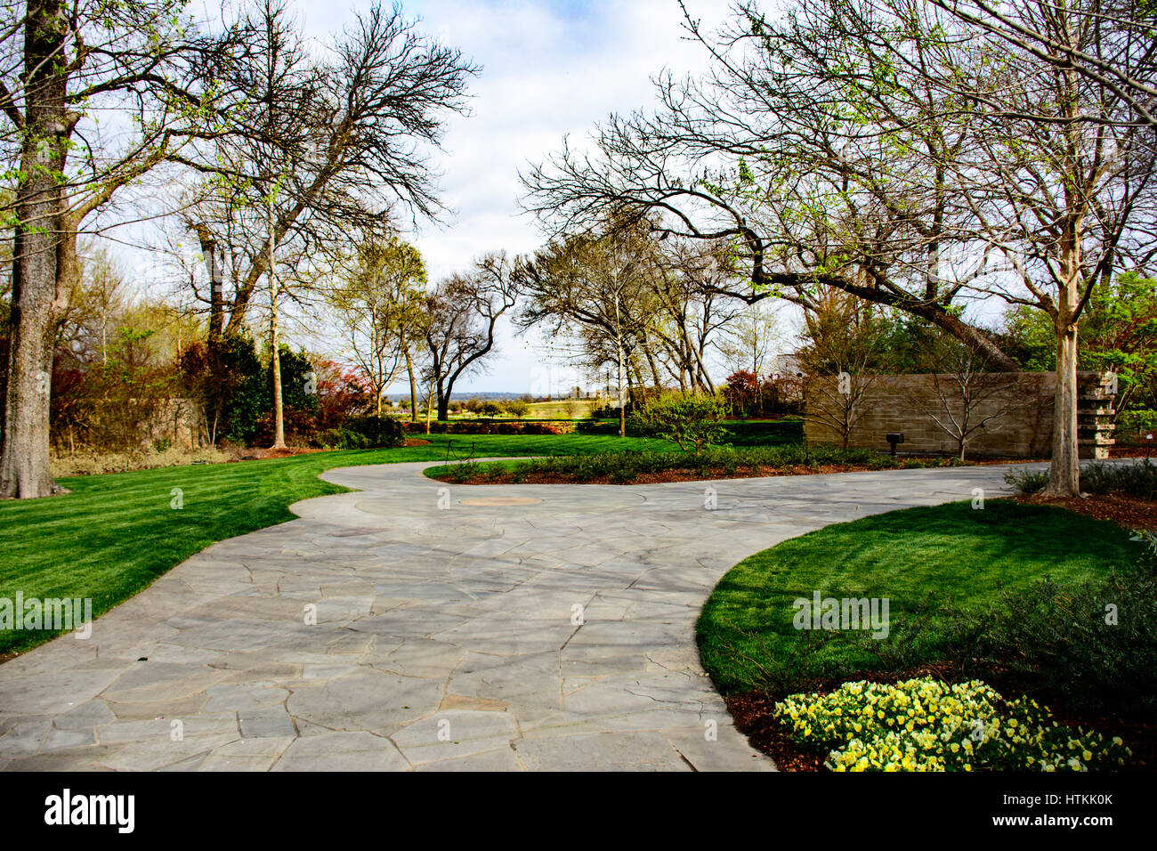 Pathway along manicured lawn with flowers and trees Stock Photo - Alamy