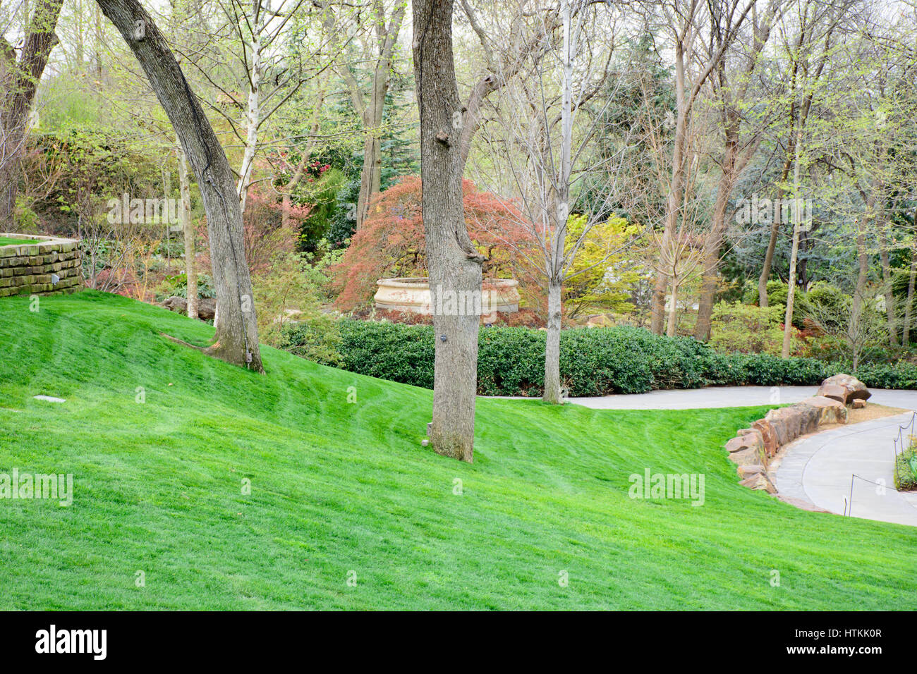 Tree lined pathway with manicured lawn leading to fountain Stock Photo ...